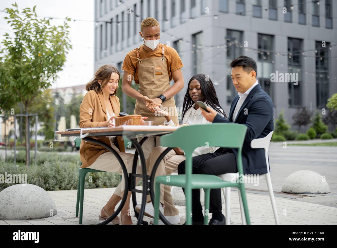 Waiter taking order from client at outdoor cafe Stock Photo - Alamy