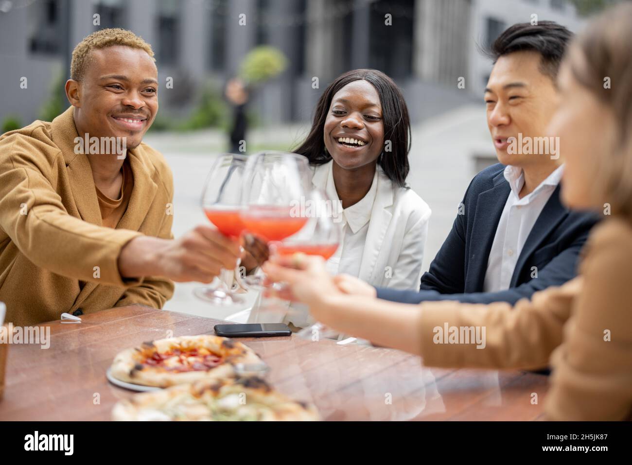 Group of business team celebrating at outdoor cafe Stock Photo - Alamy