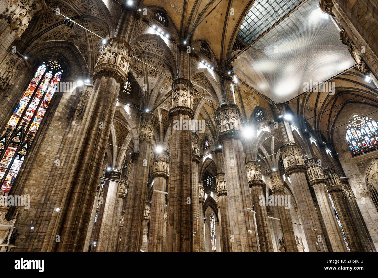 High carved columns under the illuminated ceiling in the Duomo. Italy ...