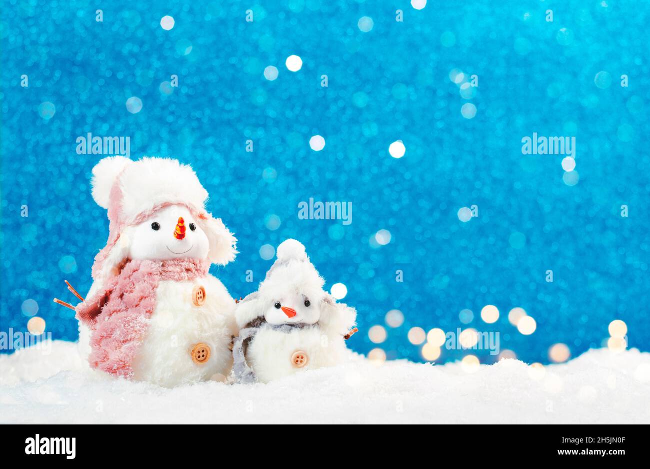 Christmas snow composition with two cute snowmen in hats and scarves in ...