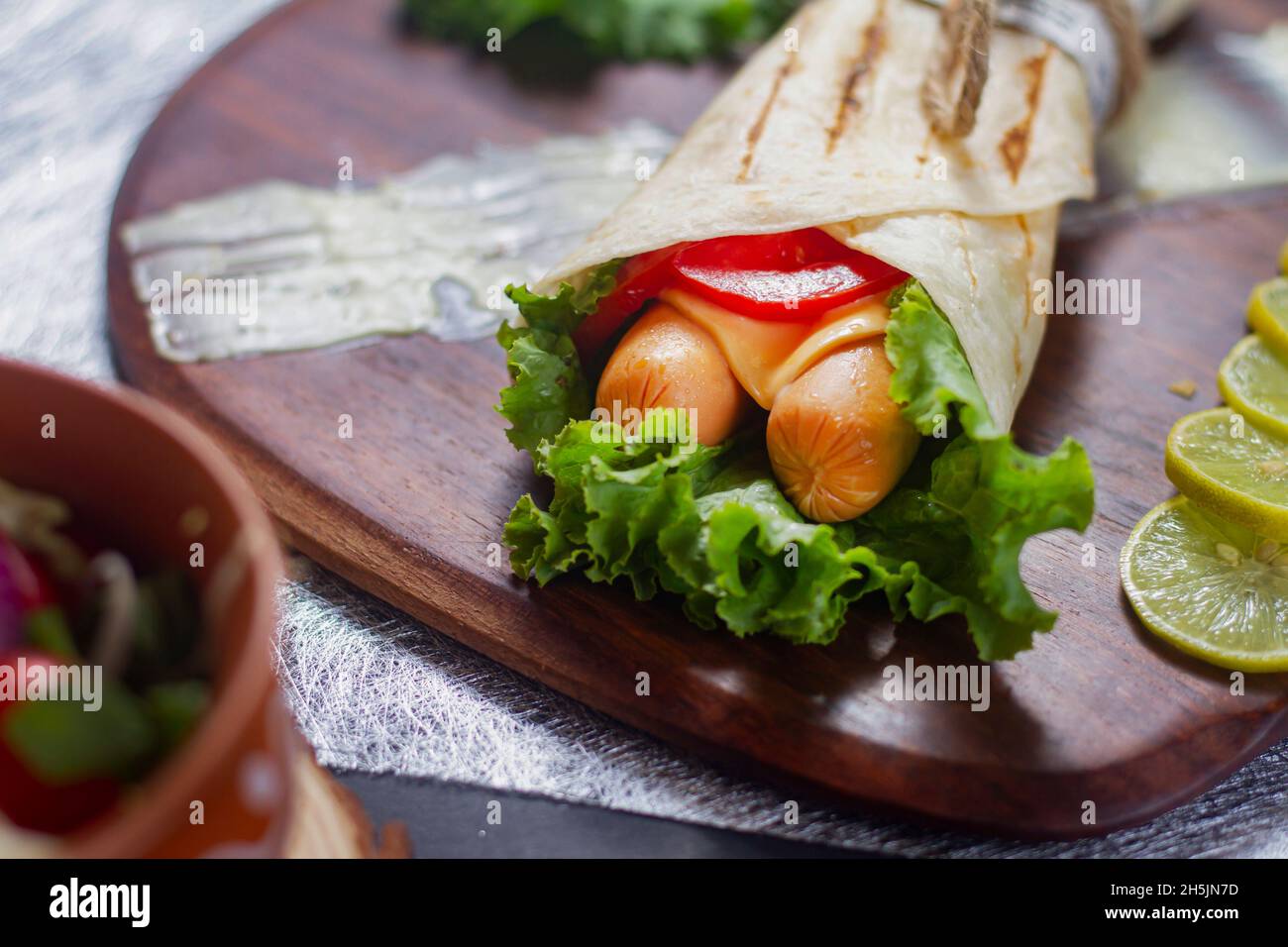 Fresh sausage roll with fresh tomatos, salad, cheese and onions ...