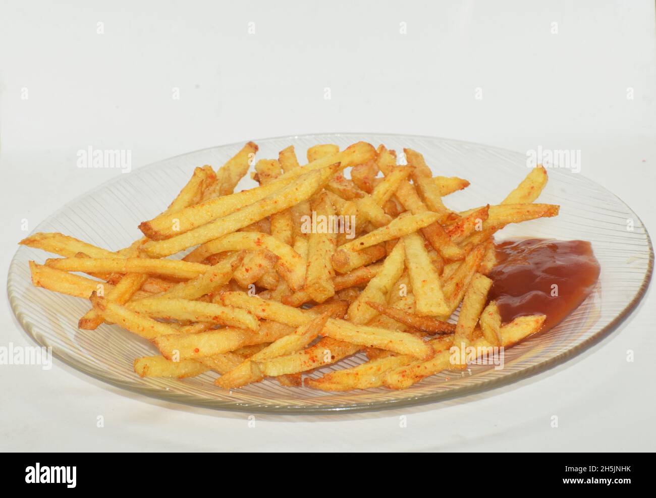 Serving of French fries with ketchup on the side on a plate isolated on ...