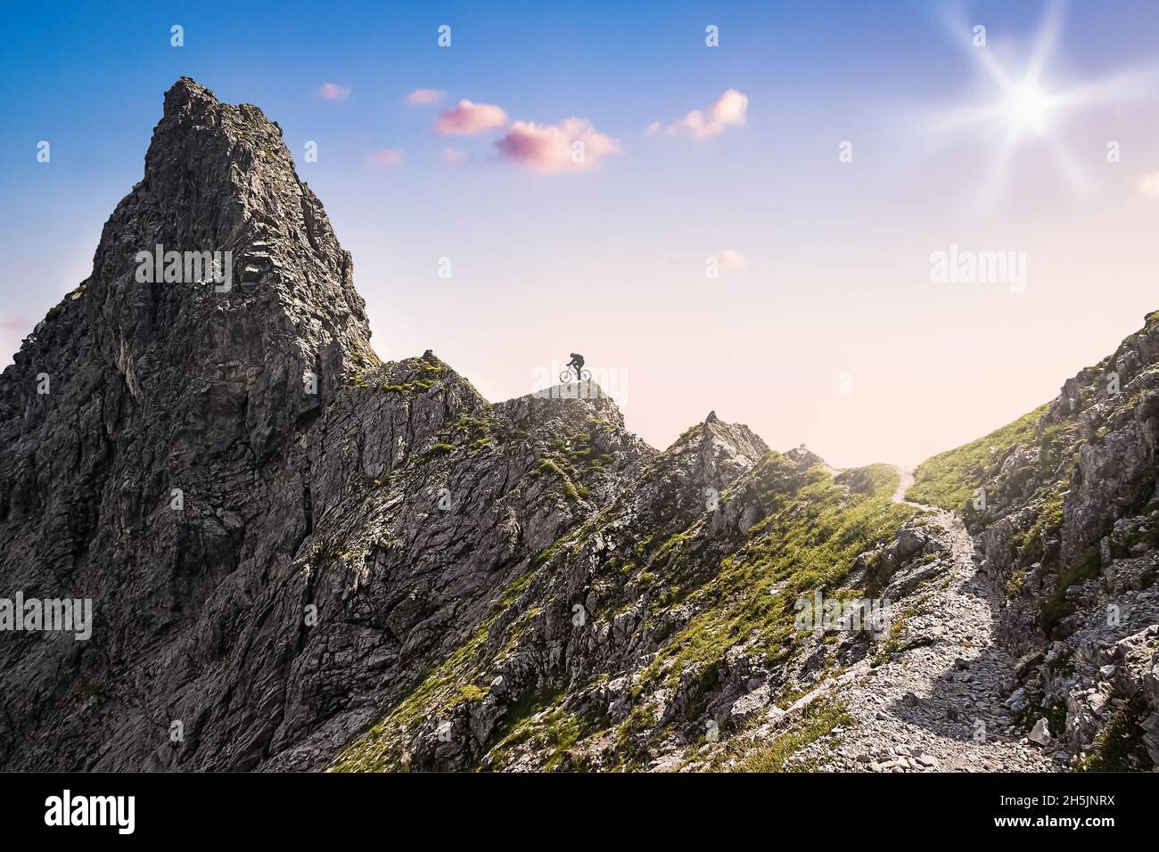 One Single Mountain Biker Riding to the Summit Stock Photo - Alamy