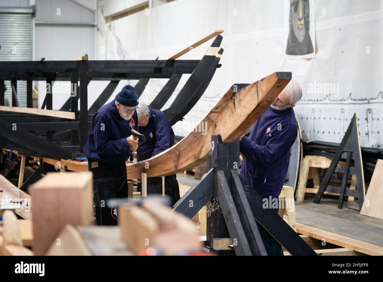 A team of volunteers work on the keel of the 88ft-long replica of the ...