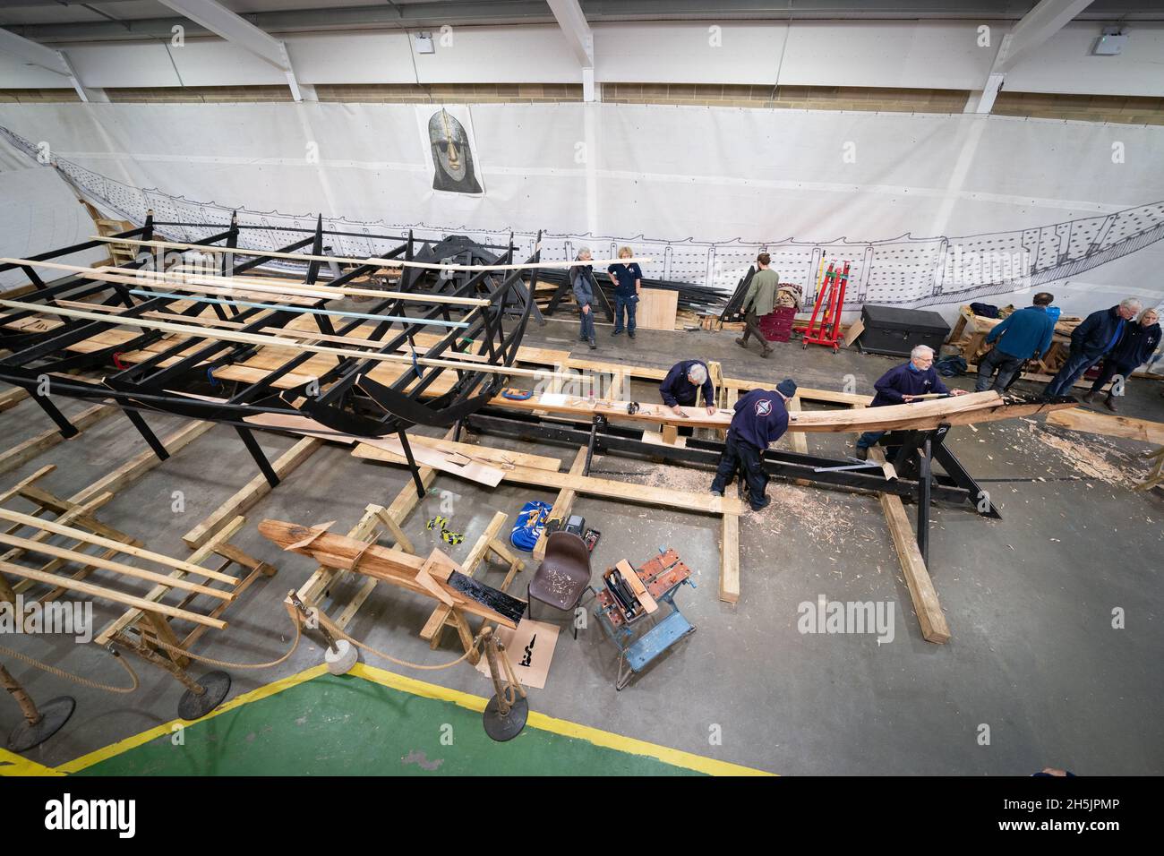 A team of volunteers work on the keel of the 88ft-long replica of the ...