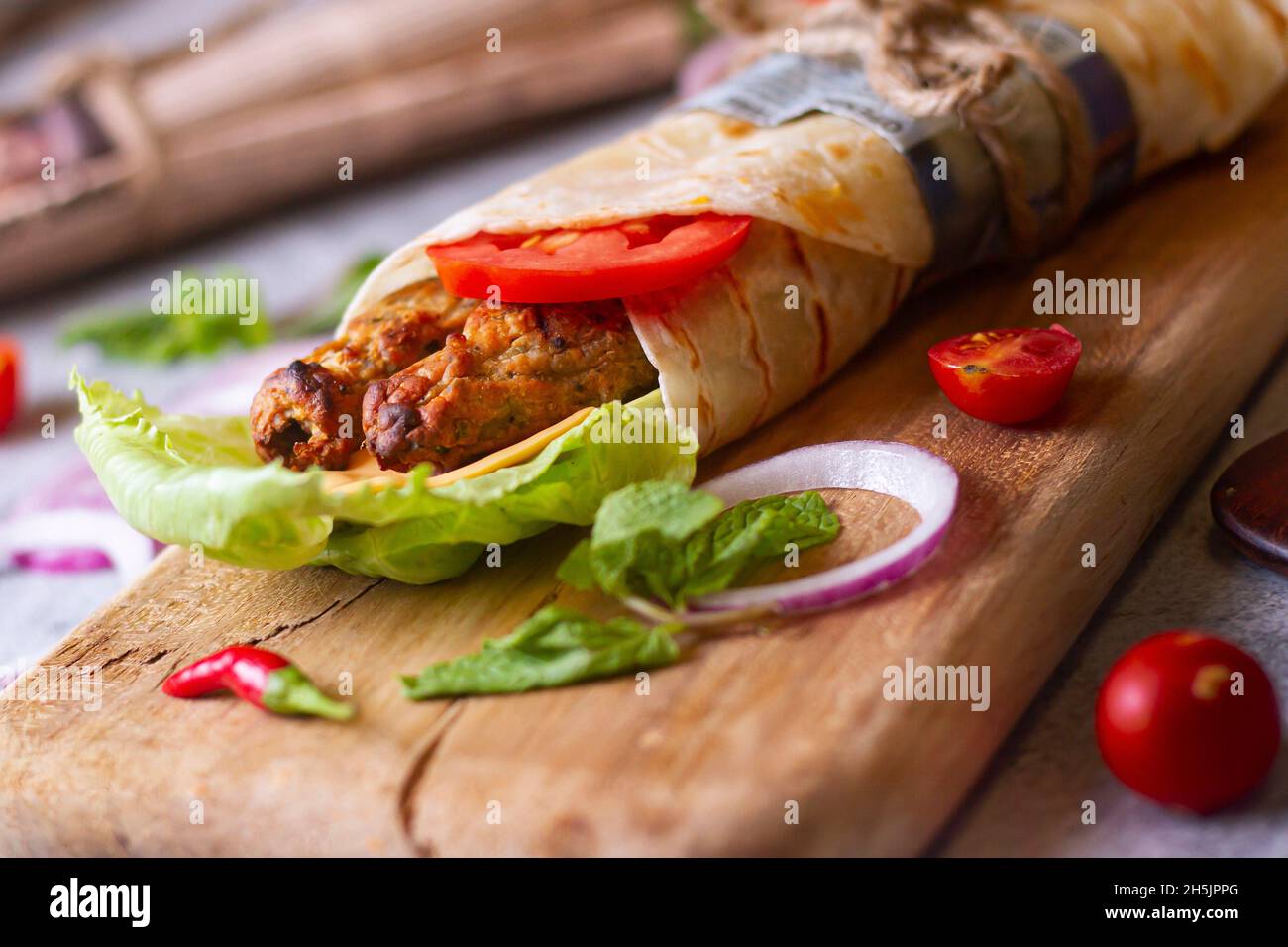 Fresh chicken seekh roll with fresh tomatos, salad, cheese and onions ...
