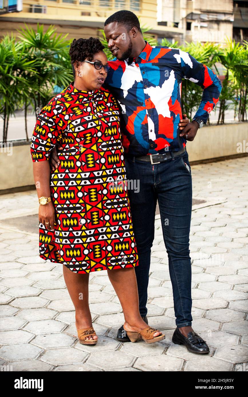 beautiful couple standing outdoors talking to each other while smiling ...