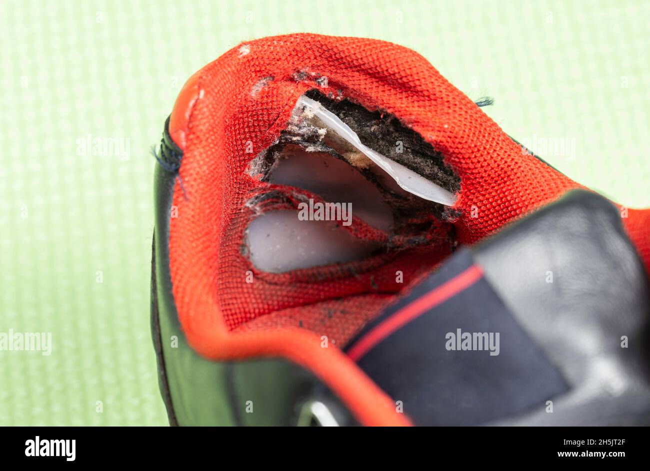 A ripped backdrop in sporty multicolored sneakers. Poor quality shoes ...