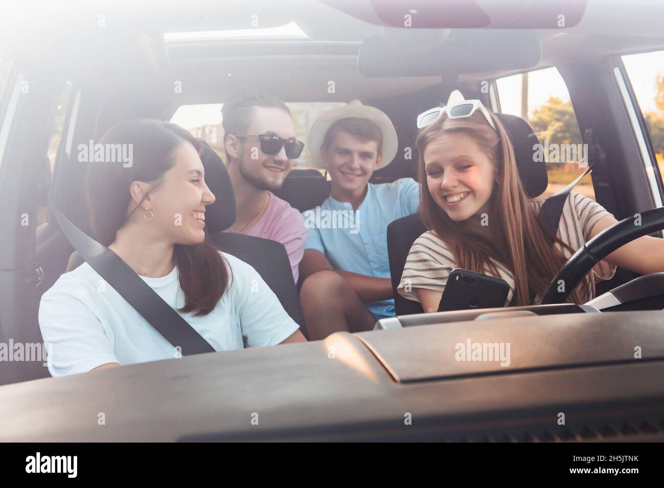 four friends in car navigation on phone. road trip Stock Photo - Alamy