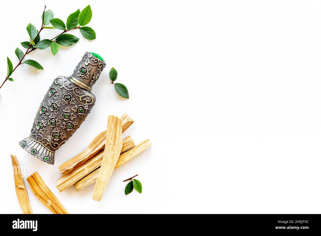 Arabic oud oil perfume in silver bottle with crystals and sticks of ...