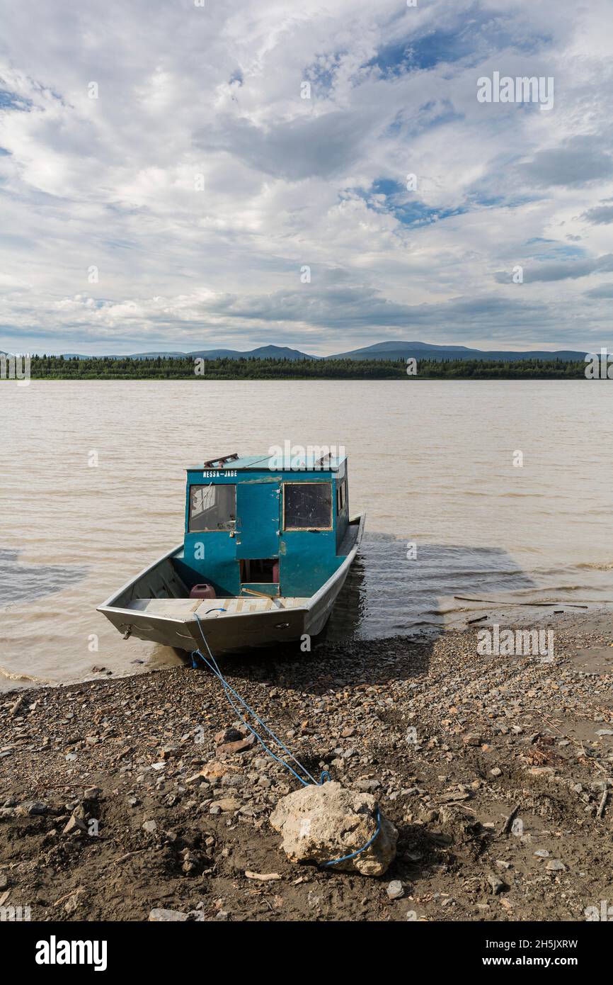 Yukon River fishing boat with a blue plywood canopy tied up to a rock ...