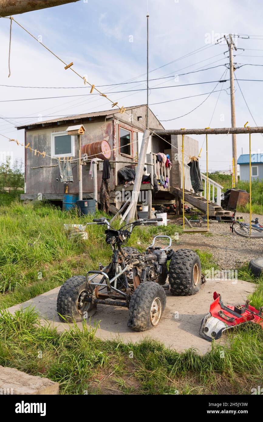 A stripped down 4-wheeler with two flat tires sits on a sheet of ...