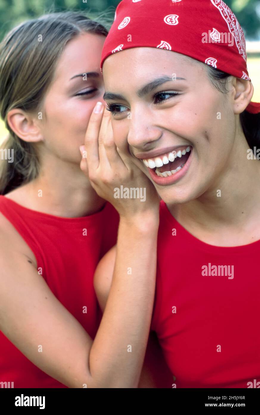Teenage girls smiling and sharing secrets outside; Germany Stock Photo ...