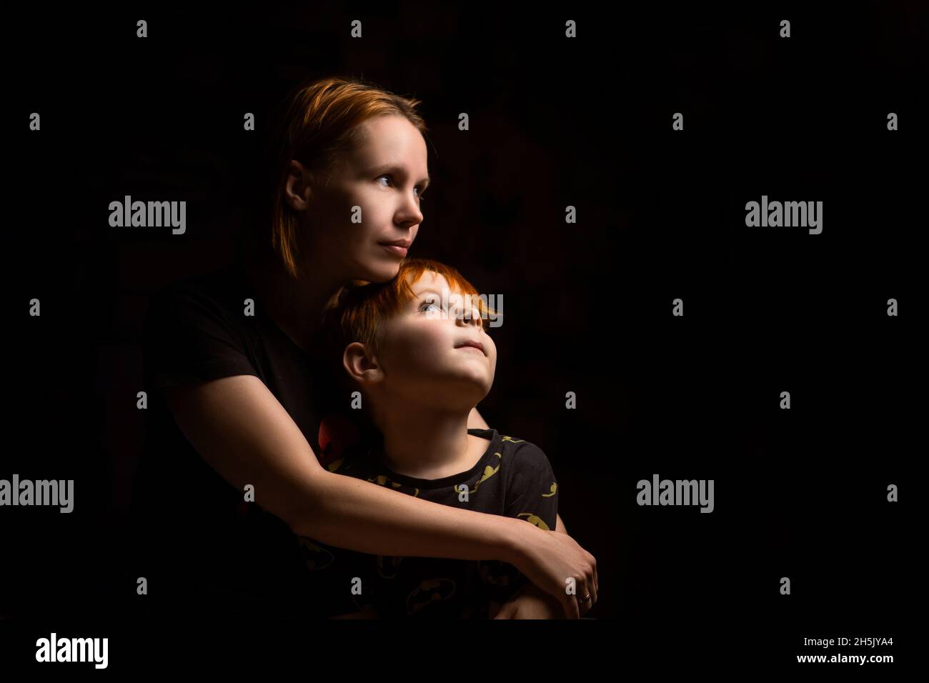 Portrait of a young boy and mom on a black background. Mother's day ...