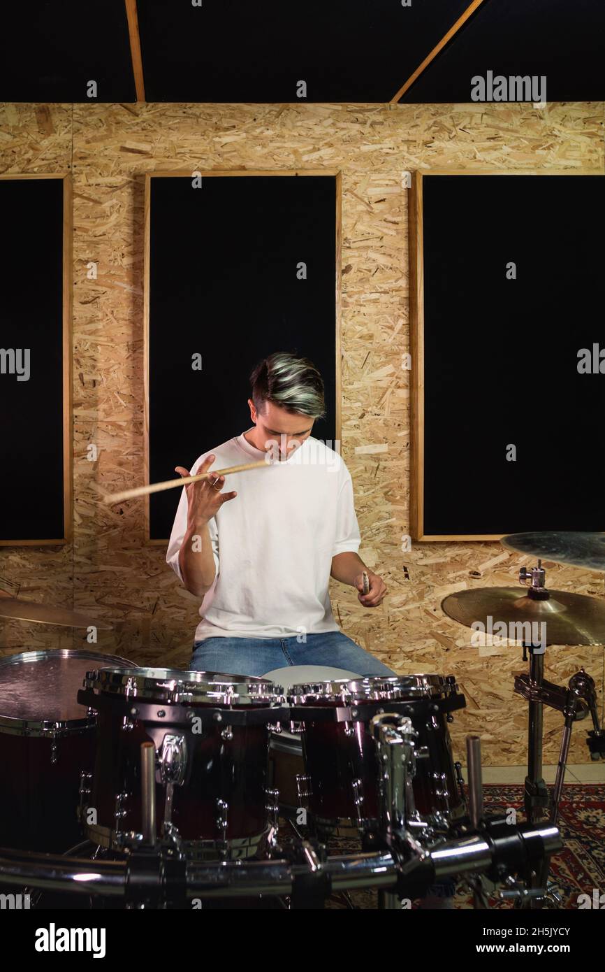 Full length young man playing drum set. Active artist beating rhythm in ...