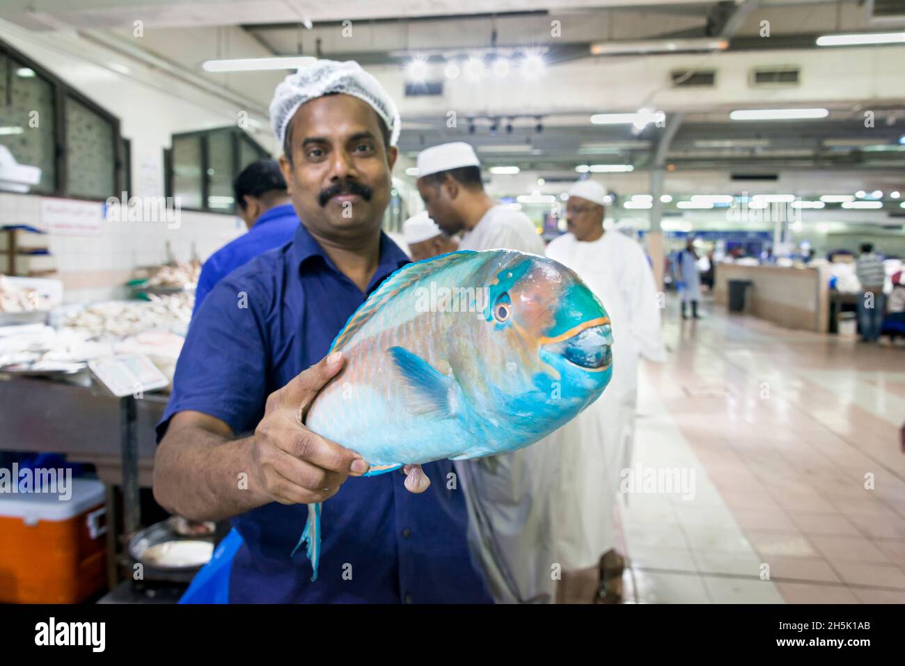 A vendor offers up a fresh catch of the day in the Fish Market in Abu ...