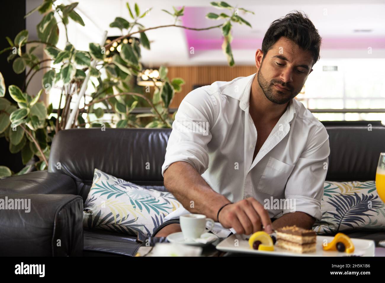 Man Eating Cake in a Hotel Lobby Bar Stock Photo - Alamy
