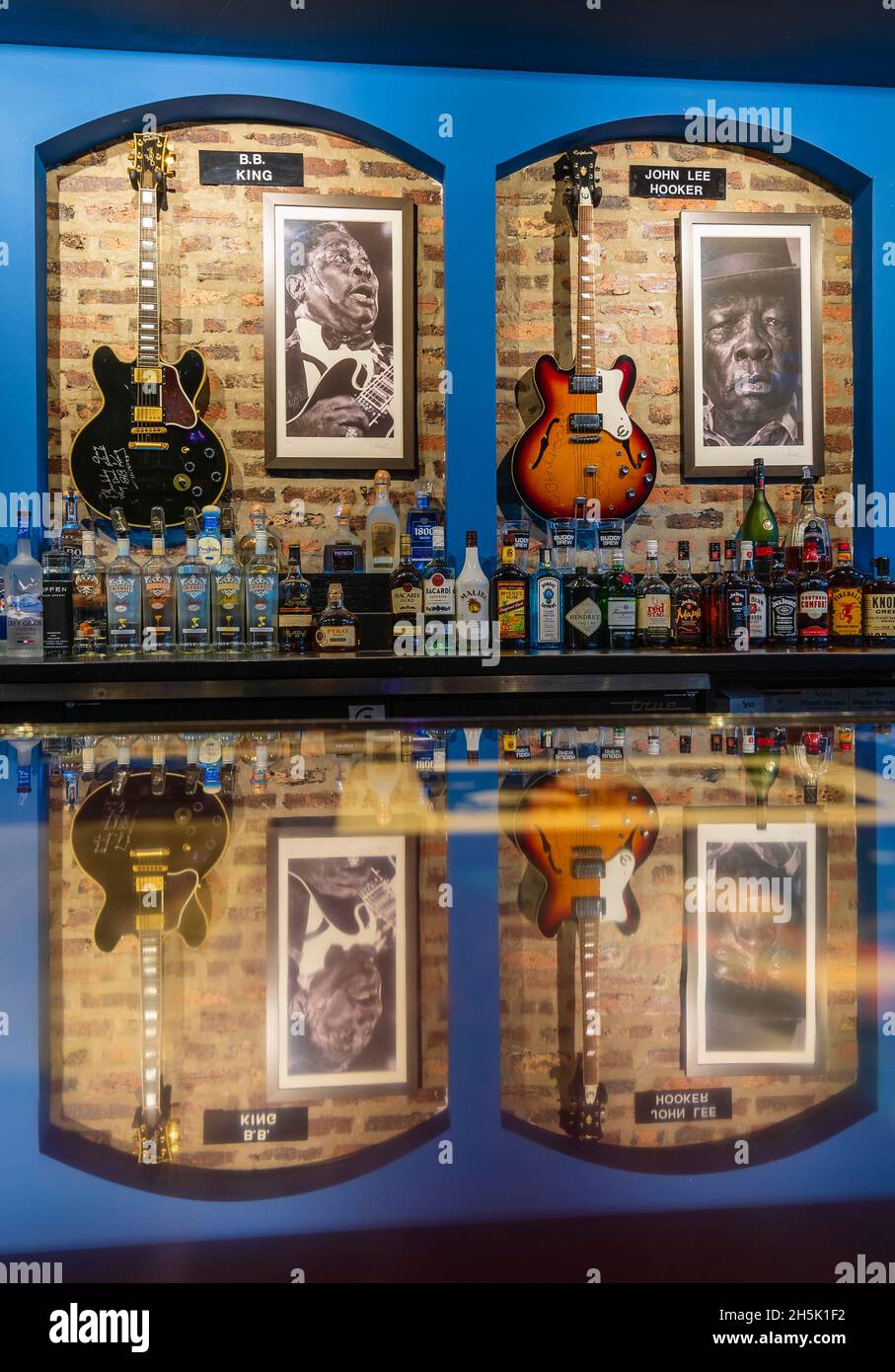 Display of photographs and guitars of Blues musicians along a bar with ...