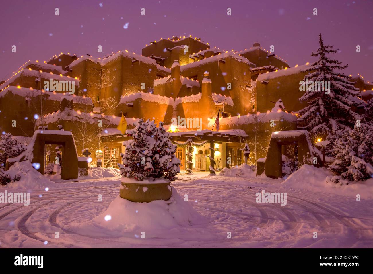 A snow topped inn is decorated for the winter holidays in Santa Fe ...