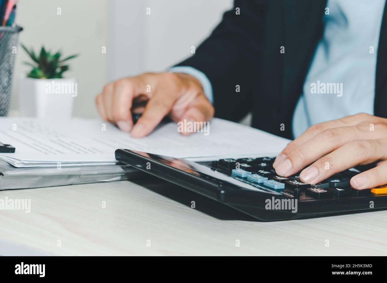 Business Man using calculator at a desk. Business finance, tax, and ...