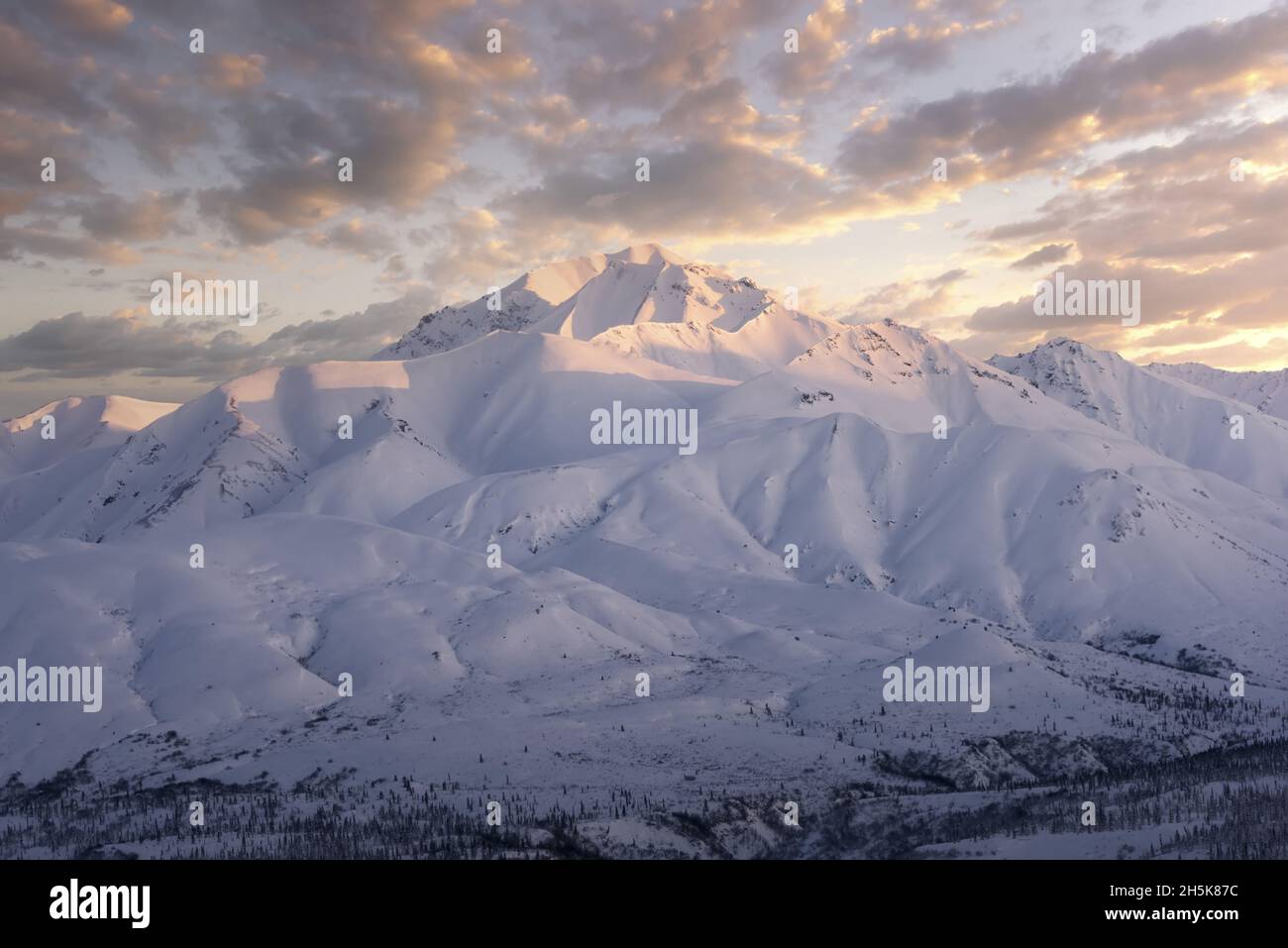 Sunset over snow covered mountains turning the view into a work of art ...