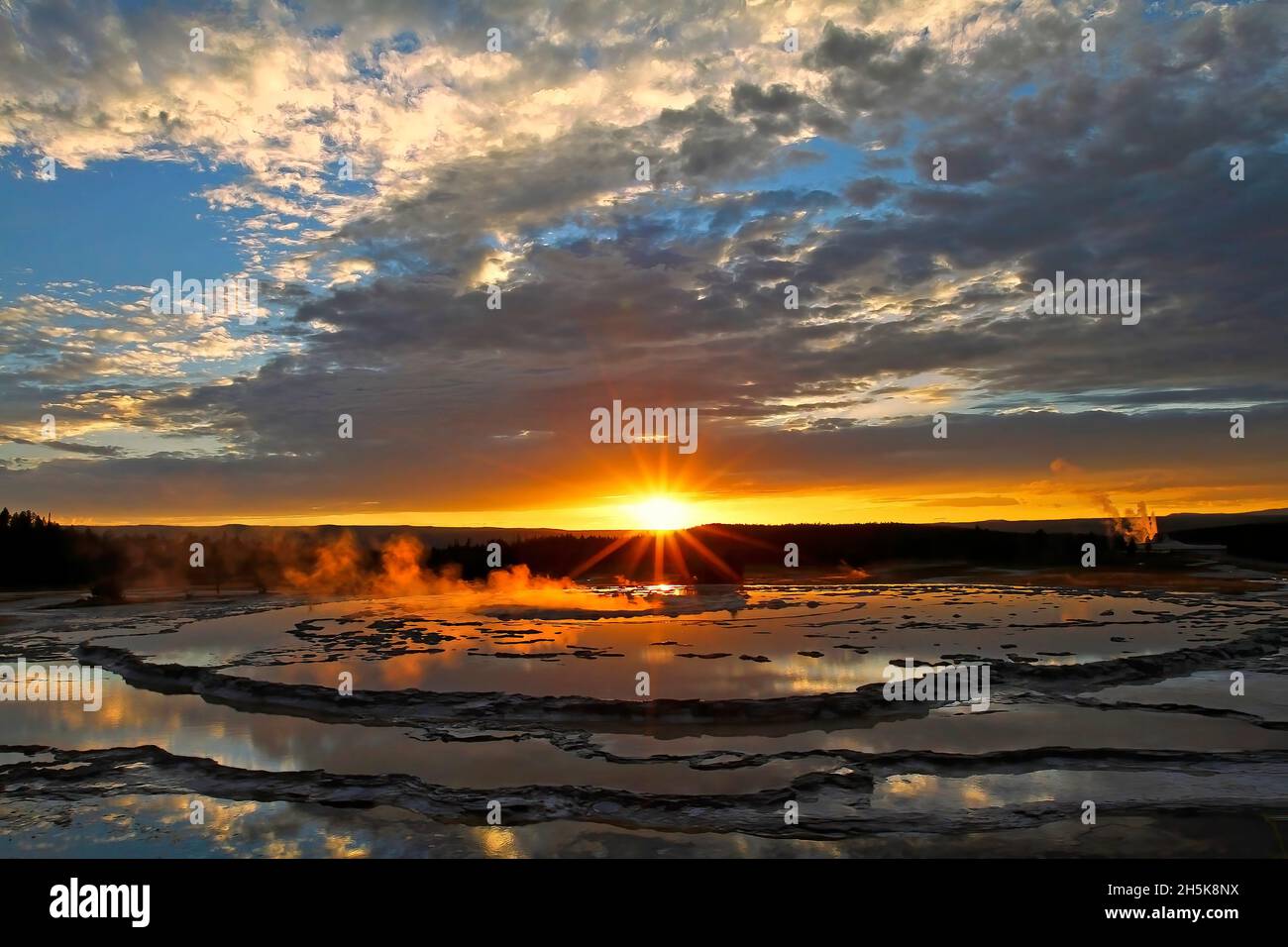 Steaming pool of geothermal water near the famous geyser Old Faithful ...