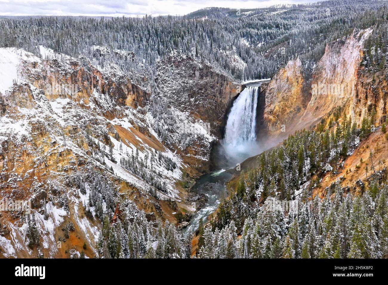Lower Yellowstone Falls with snow covered surrounding mountains and ...