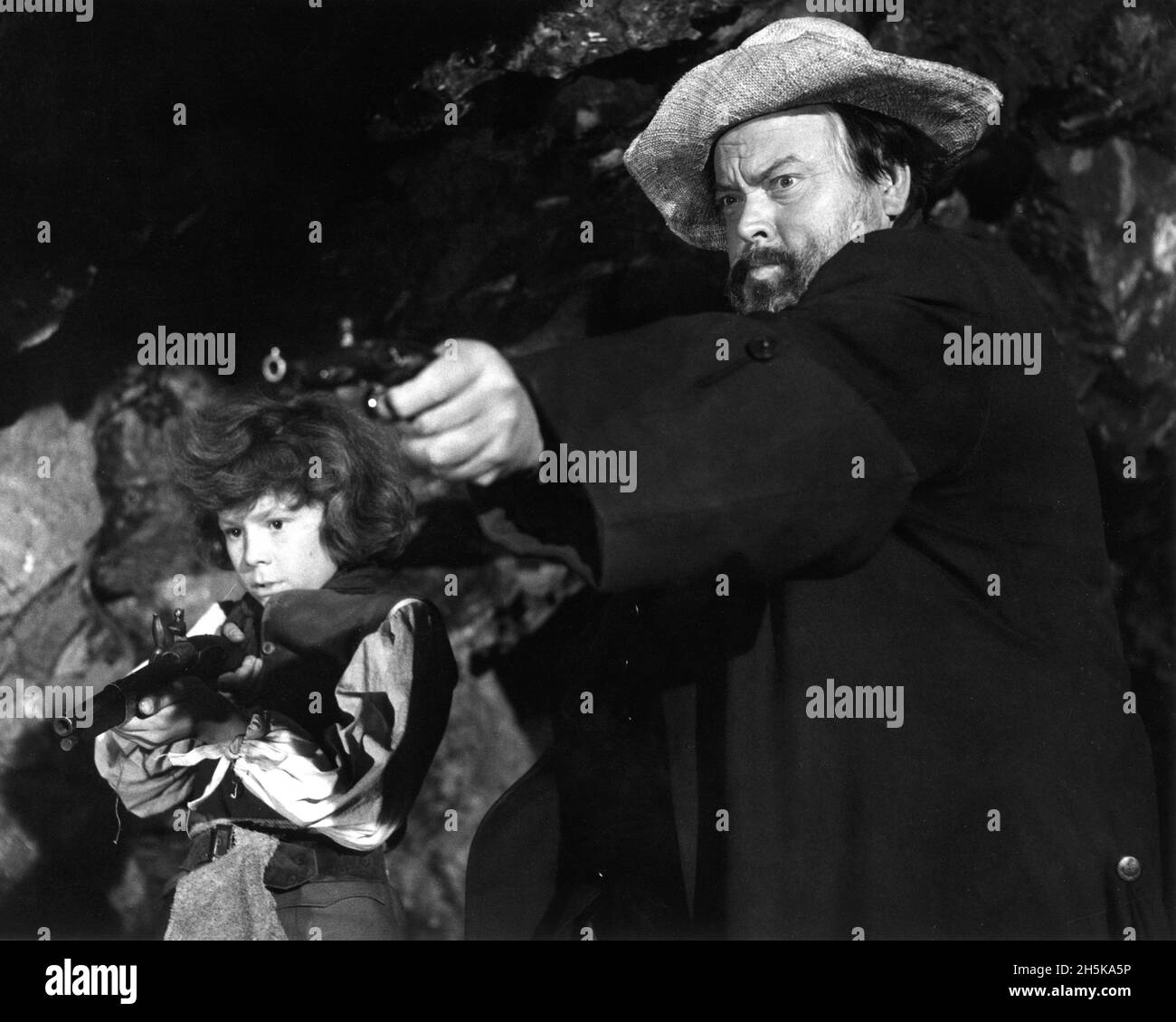 KIM BURFIELD as Jim Hawkins and ORSON WELLES as Long John Silver in ...