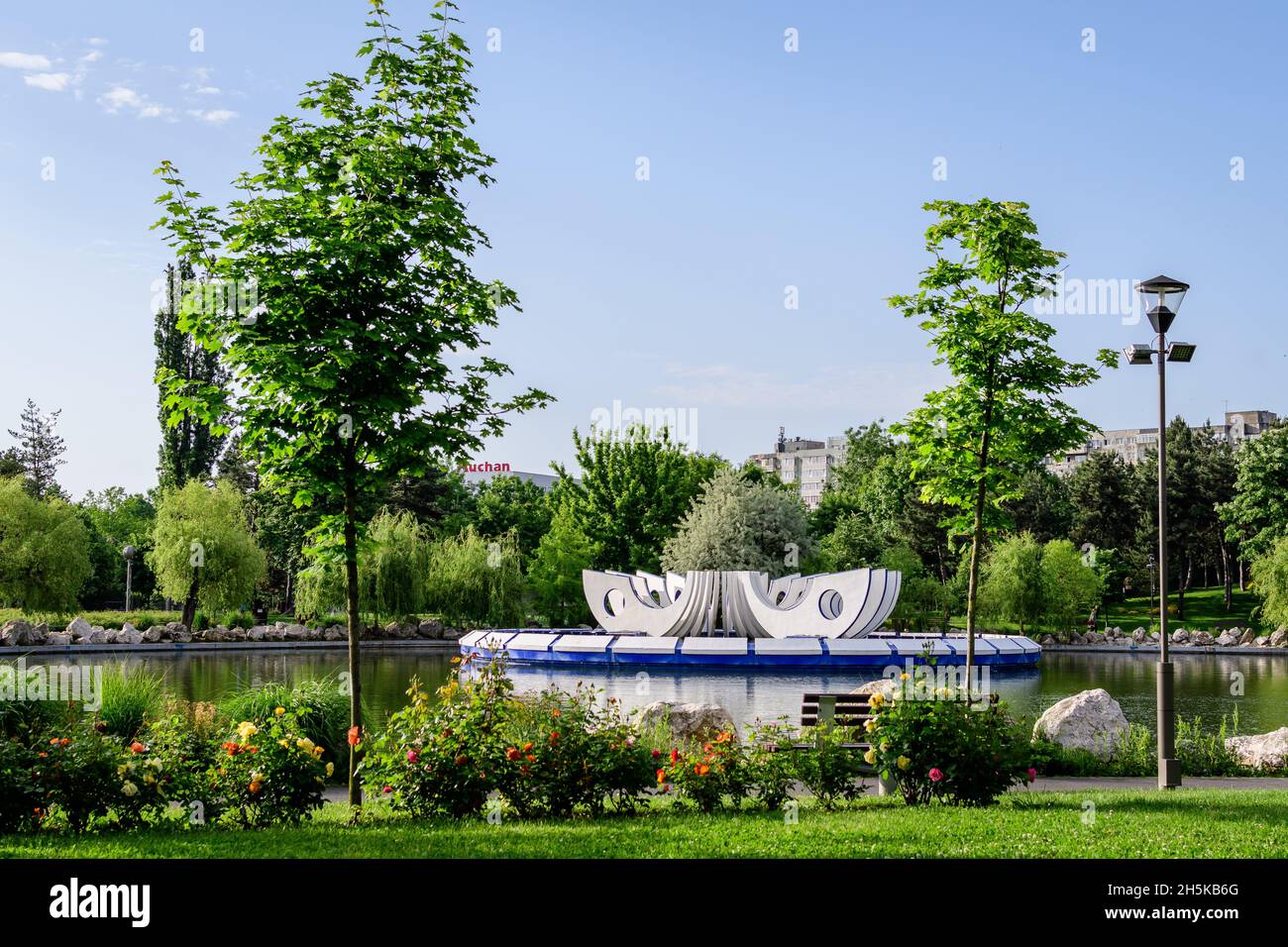 Landscape with the lake, decorative fountain and vivid green trees in ...