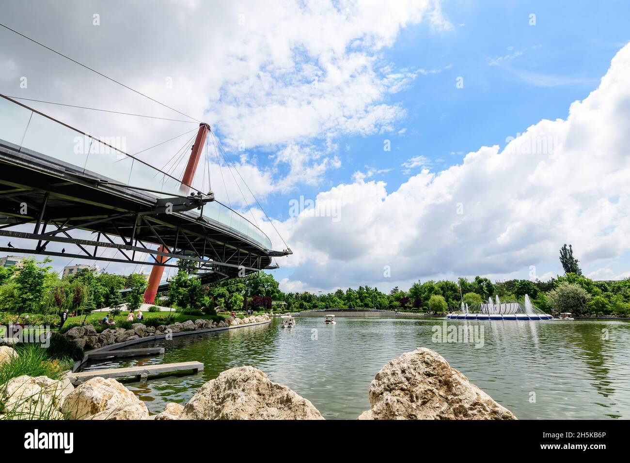 Landscape with the modern red metallic bridge, lake and vivid green ...
