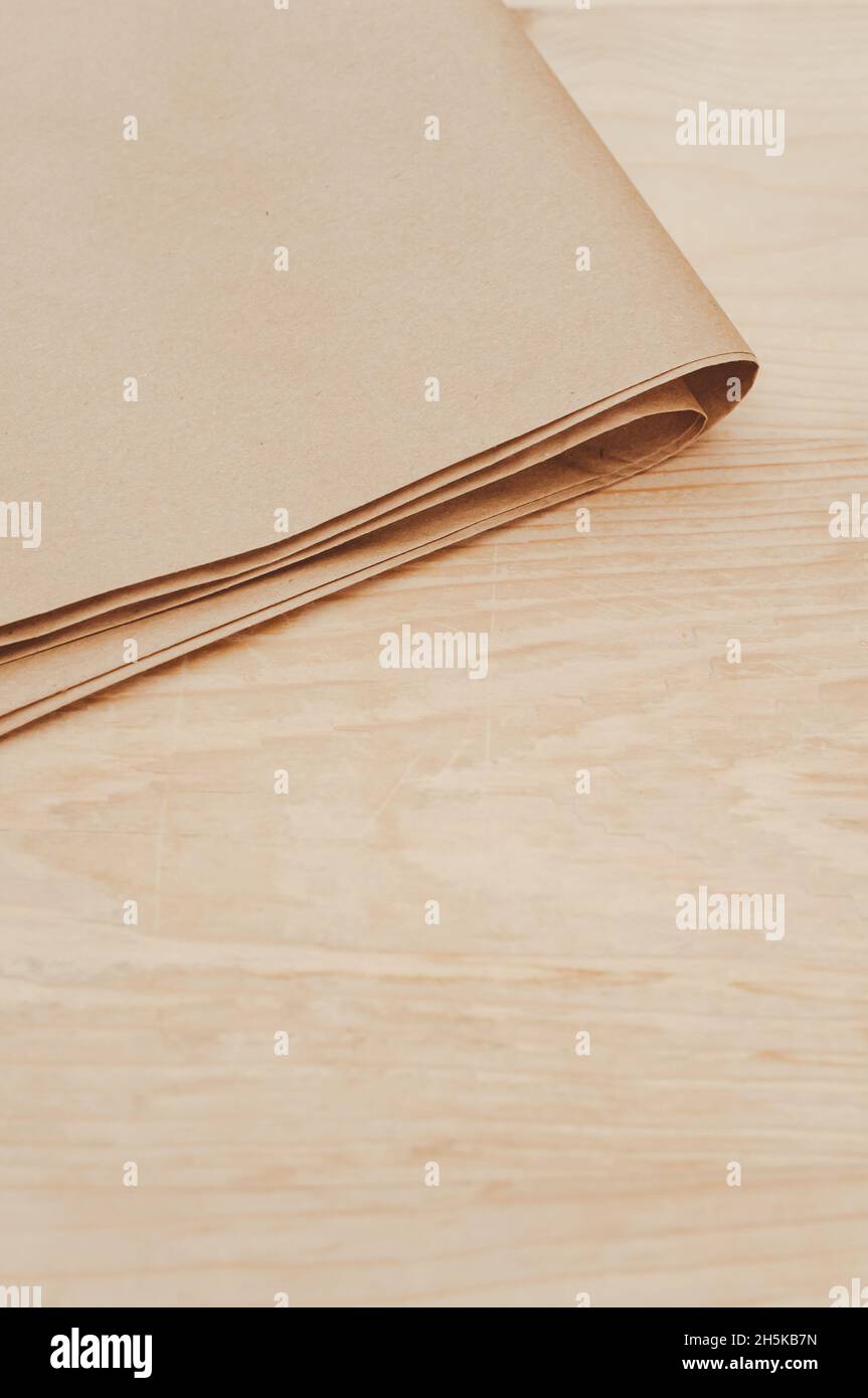 folded brown paper on a rustic wooden background with space for text ...