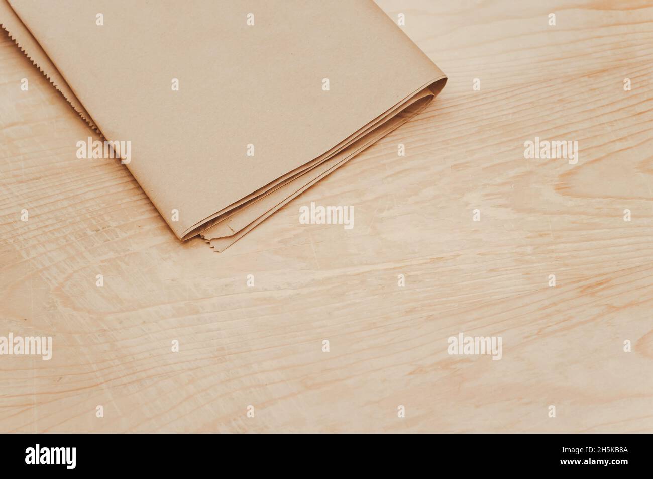 folded brown paper on a rustic wooden background with space for text ...