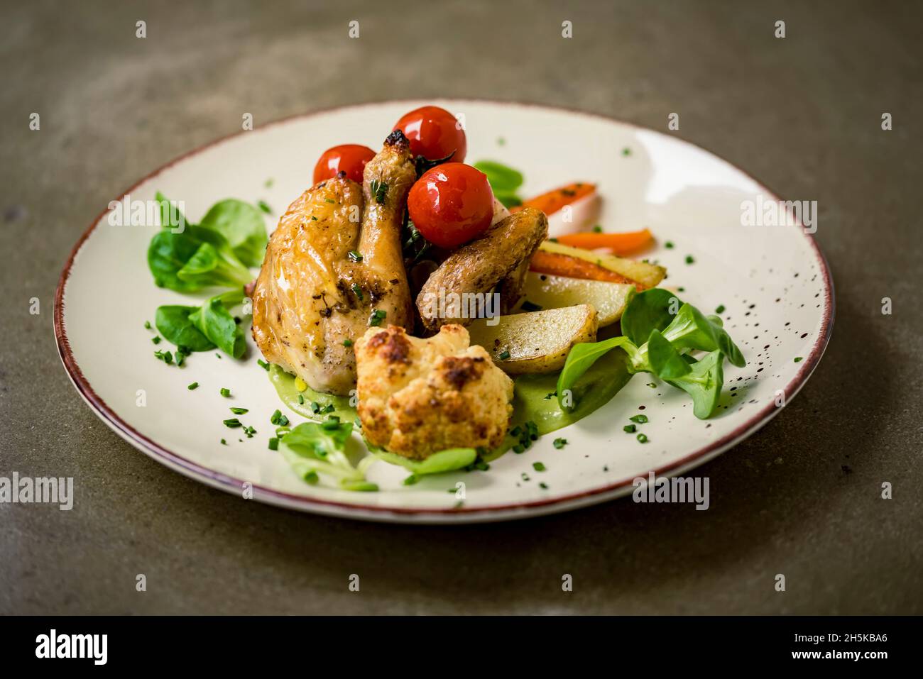 Roasted chicken with vegetables on a plate; Studio Stock Photo - Alamy