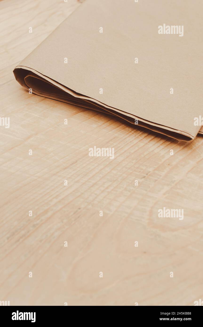 folded brown paper on a rustic wooden background with space for text ...