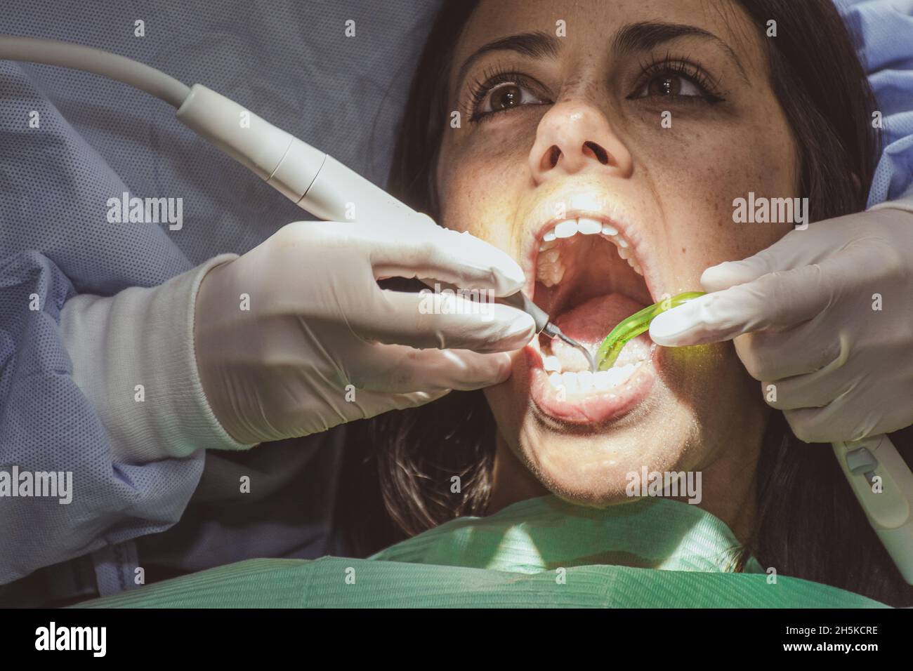 Young woman in a dental clinic while having a dental cleaning treatment ...