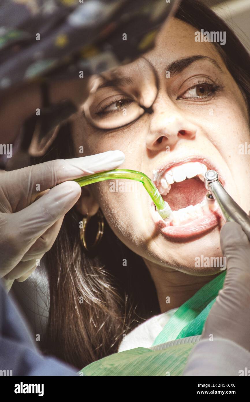 Young woman in a dental clinic while having a dental cleaning treatment ...