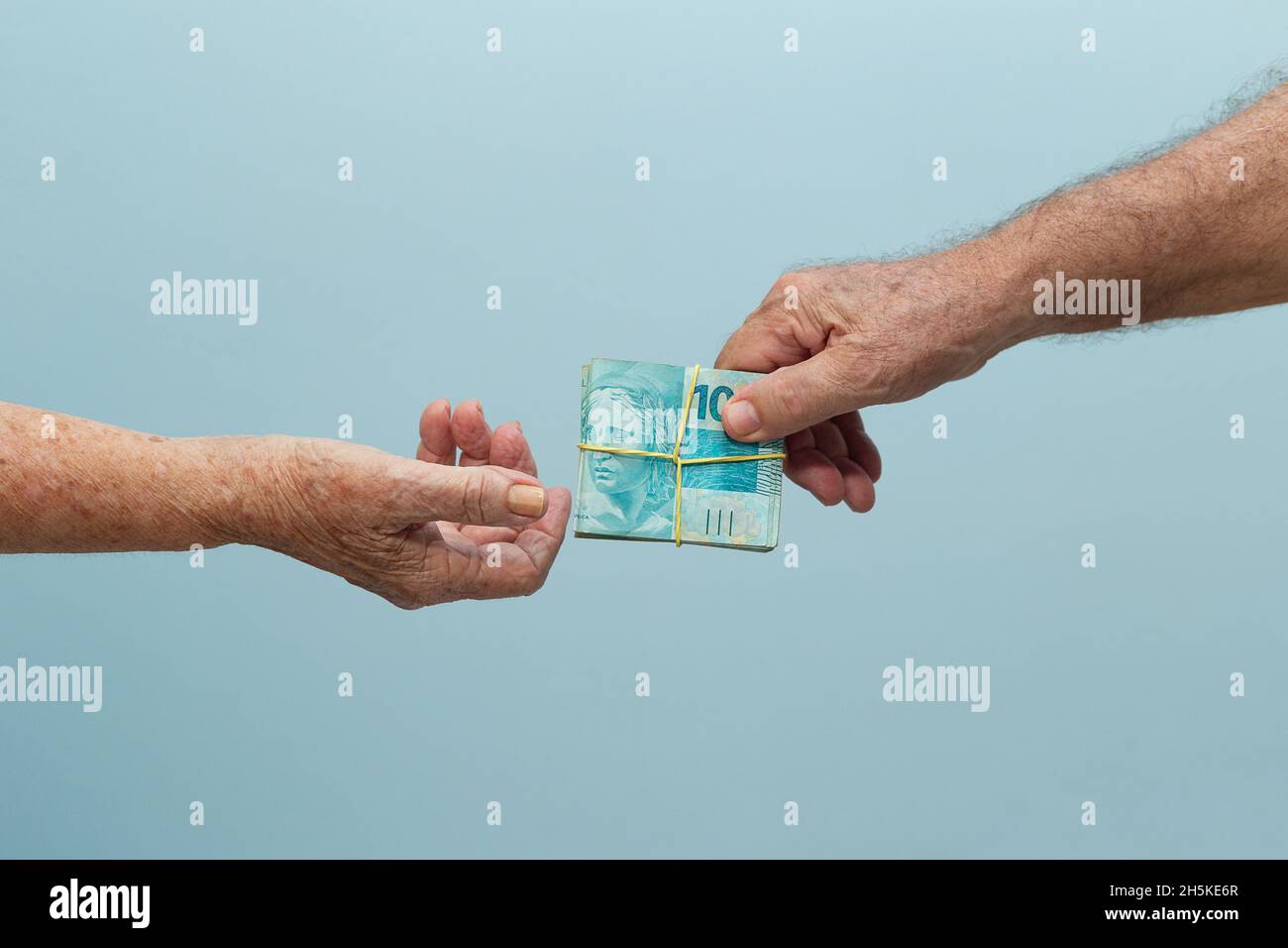 Hand of an elderly man making payment to another person. Hands of two ...