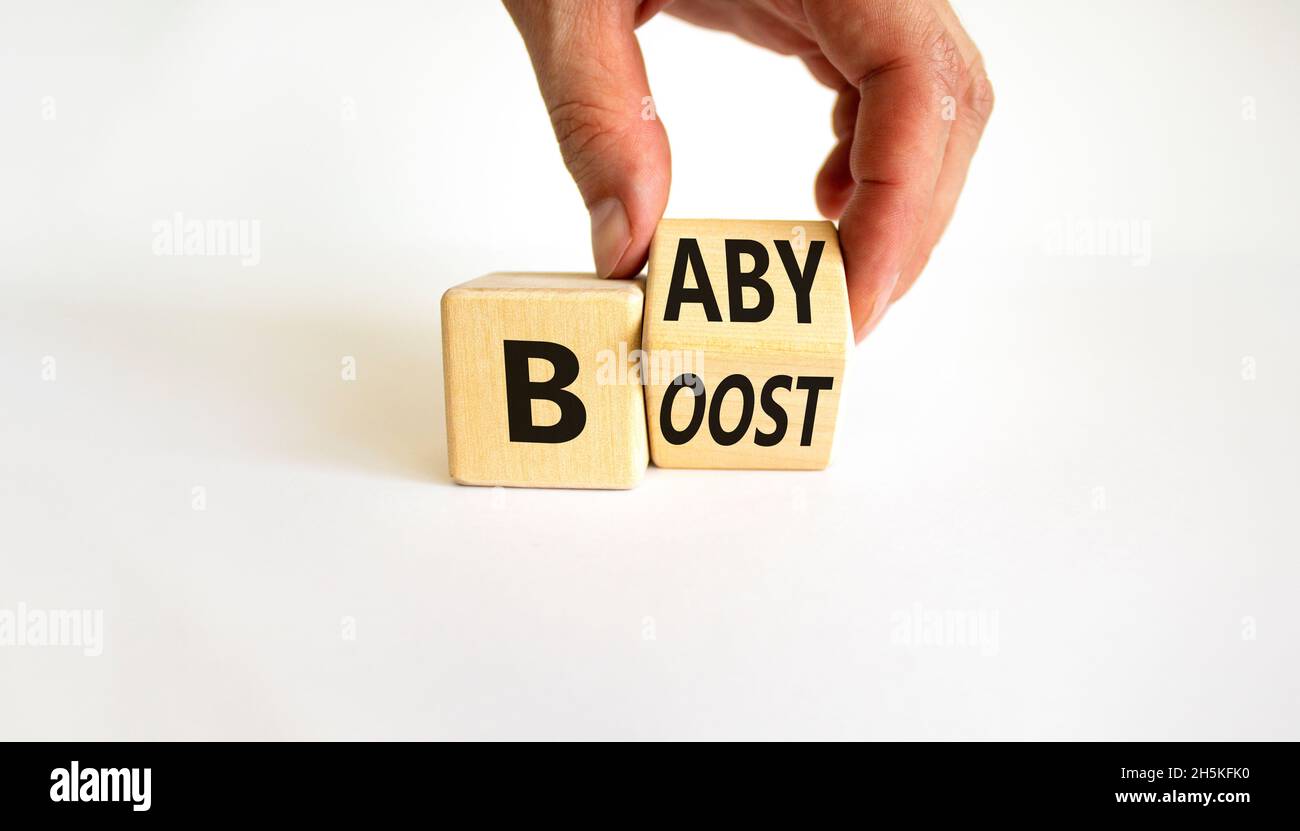 Baby boost symbol. Businessman turns a wooden cube and changes the word ...