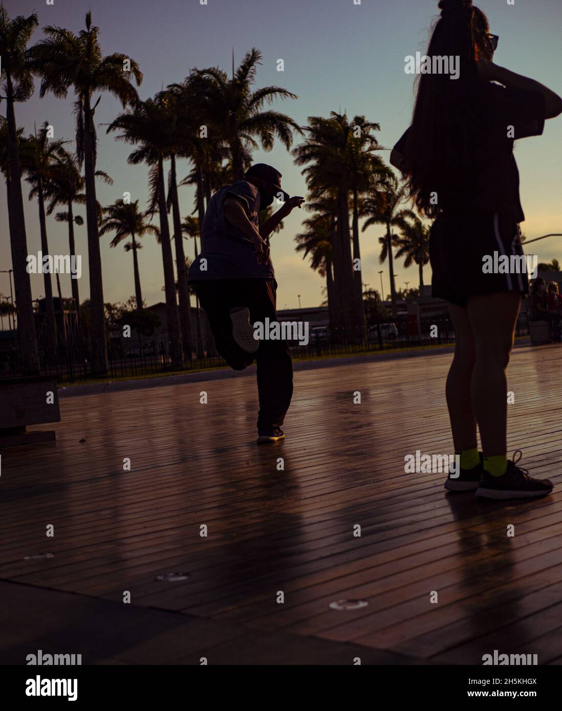 Young person breakdancing in a park surrounded by palm trees in the ...