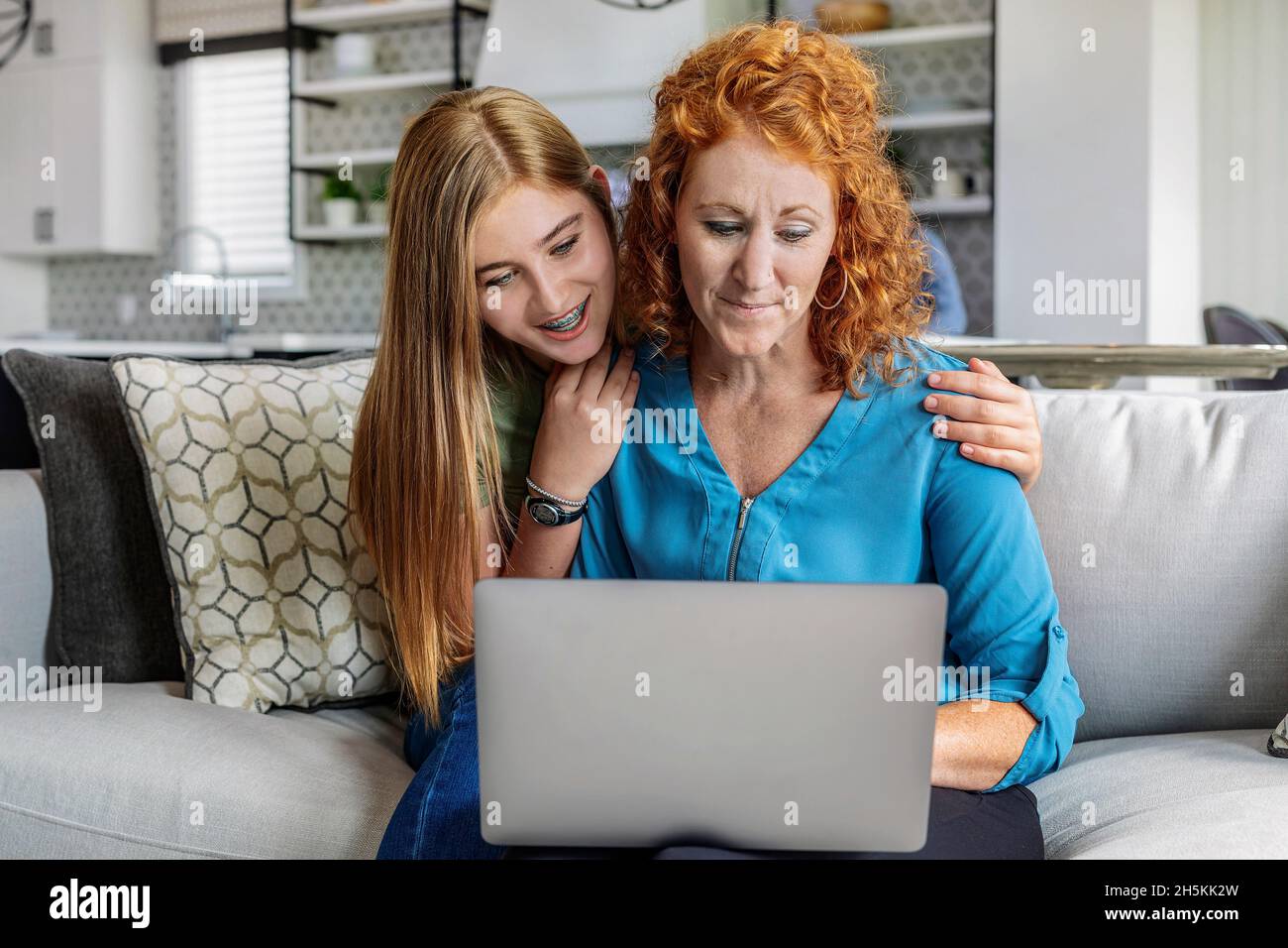 Mother and daughter looking at a laptop computer together; Edmonton ...