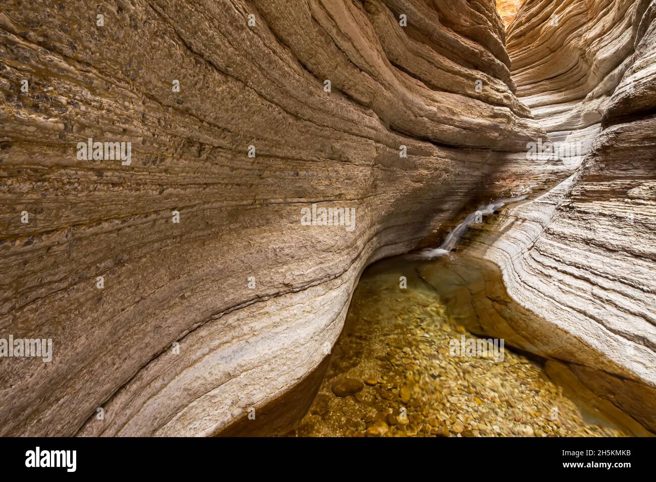 A small waterfall flows at the end of a small desert canyon Stock Photo ...
