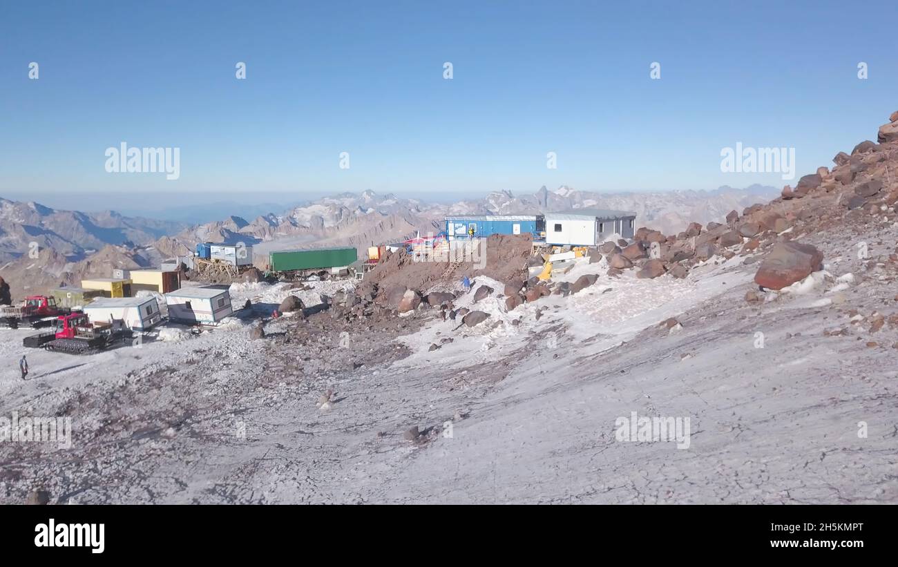 Snowmobiles and houses in snowy mountains. Clip. Top view of snowcats ...