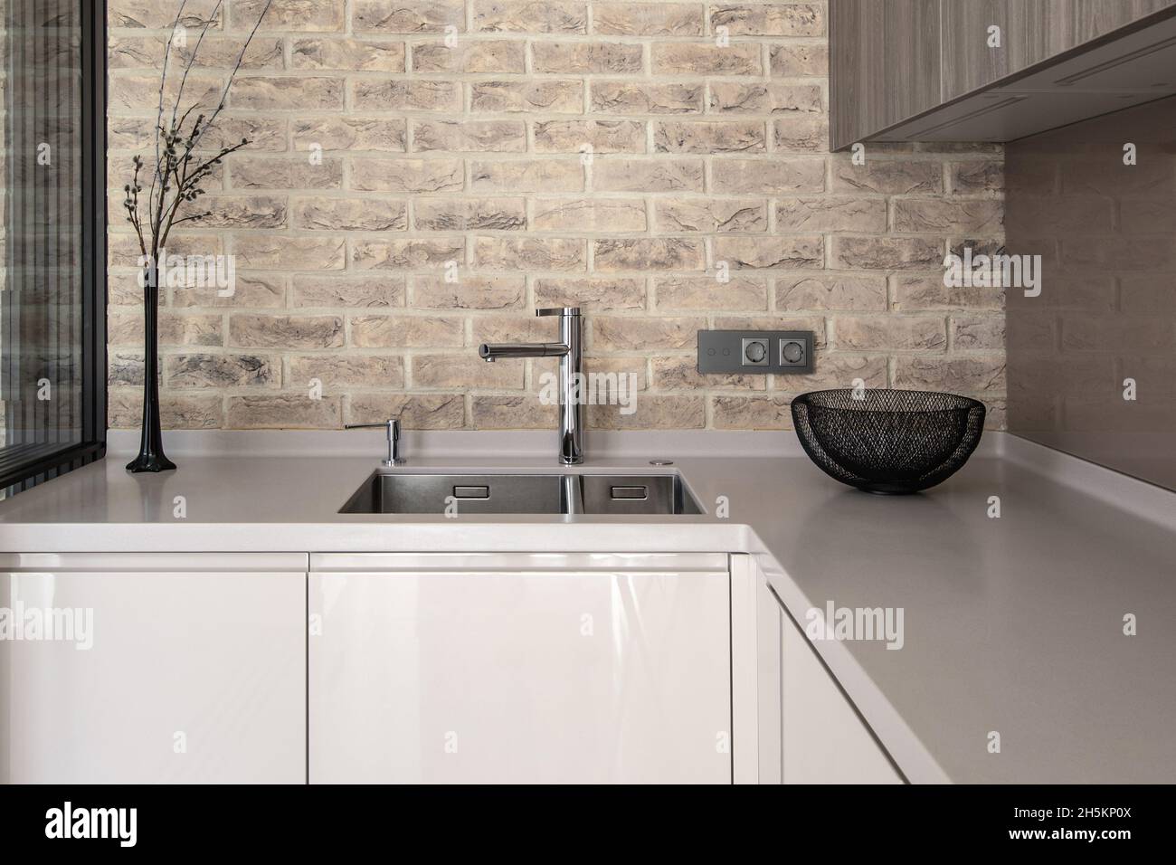 Kitchen contemporary style in beige tones with brick wall and shiny ...
