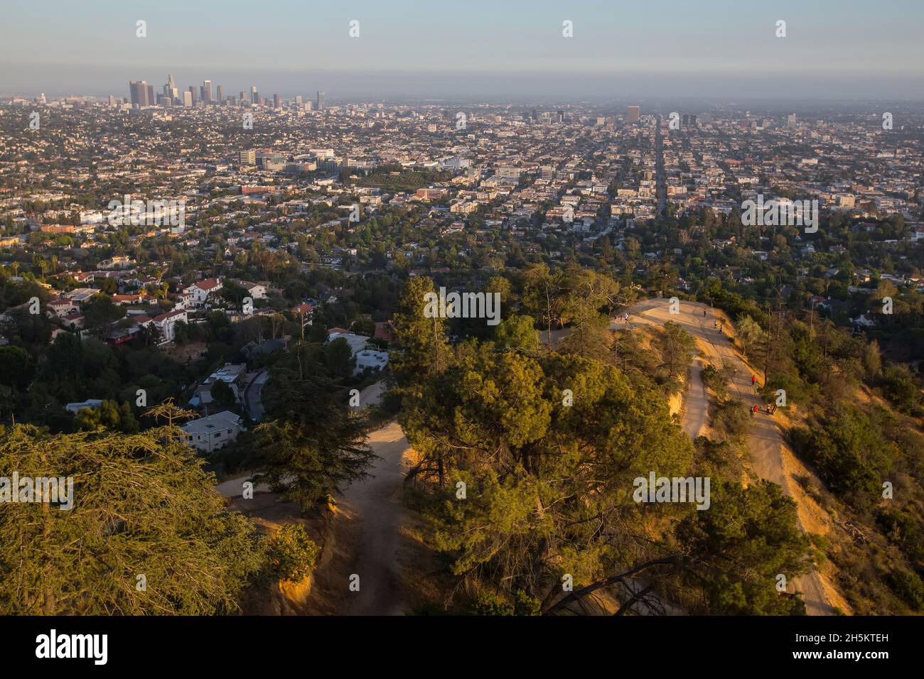 People hike up the Griffith park trail with the Los Angeles skyline in ...