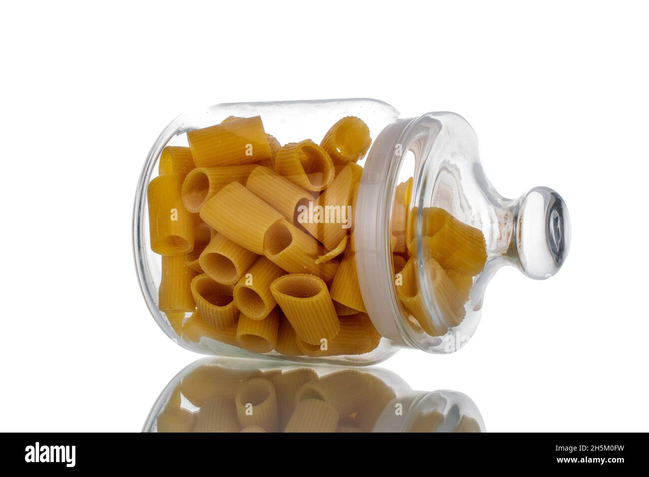 Bright yellow uncooked cannelloni pasta in a glass jar, close-up ...