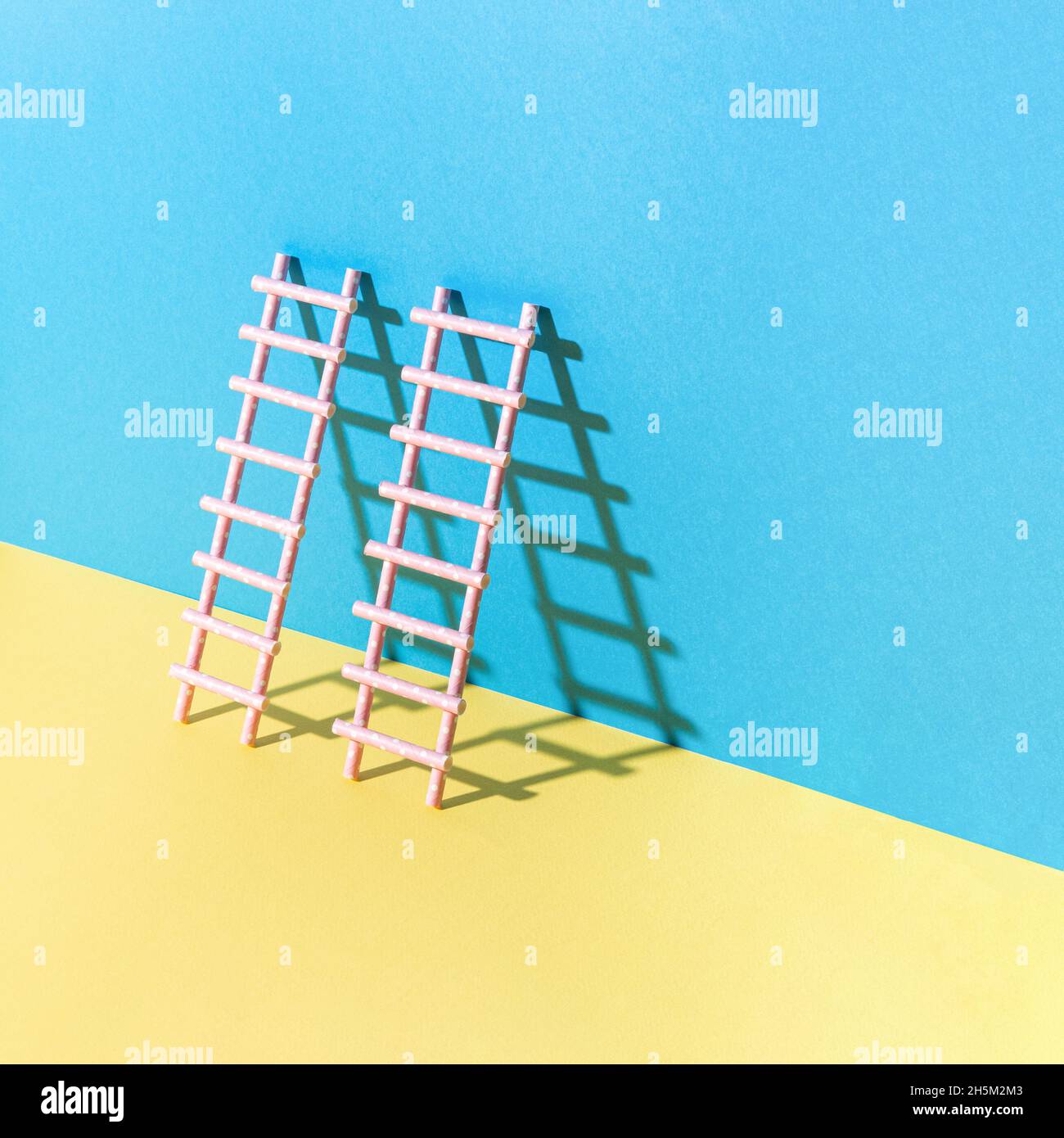 Creative ladder with sunshine shadow on a yellow and blue pastel ...
