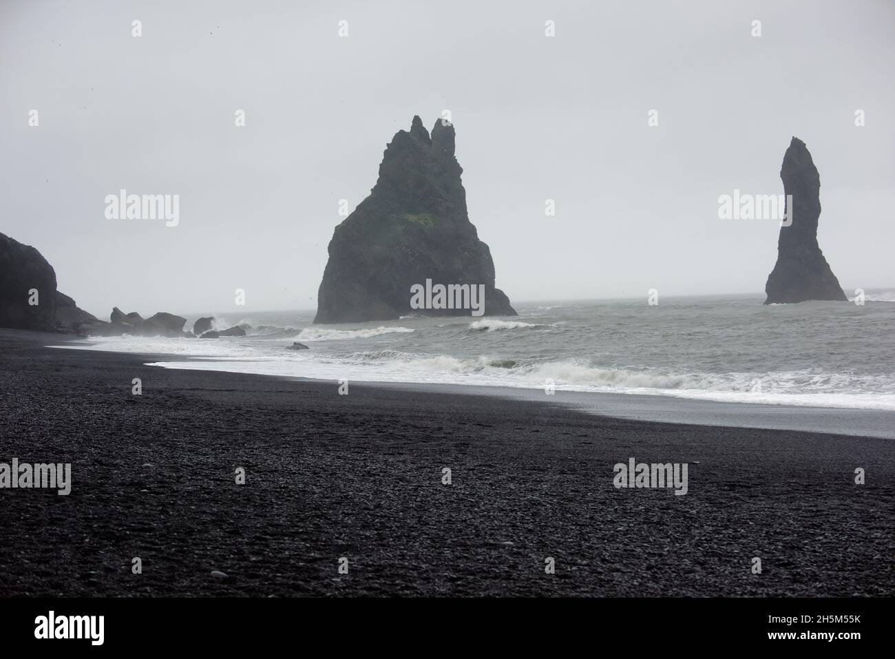 The Reynisdrangar basalt sea stacks and the Reynisfjara black sand ...