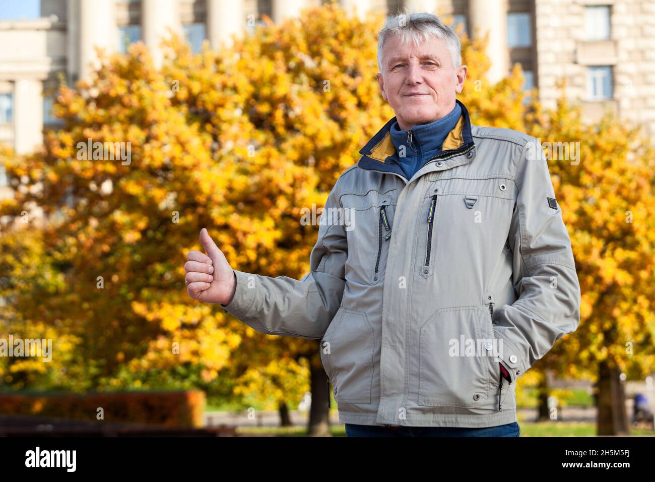 Elder men shows thumb up, autumn season with yellow leaves background ...