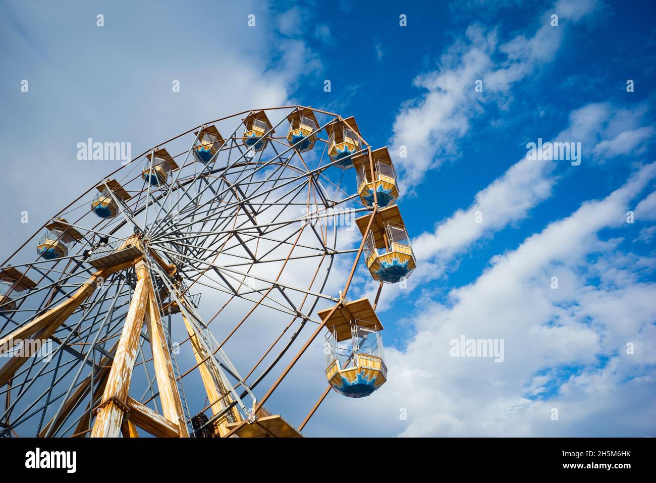 Looking up at a big wheel against a blue and cloud sky at Bridlington ...