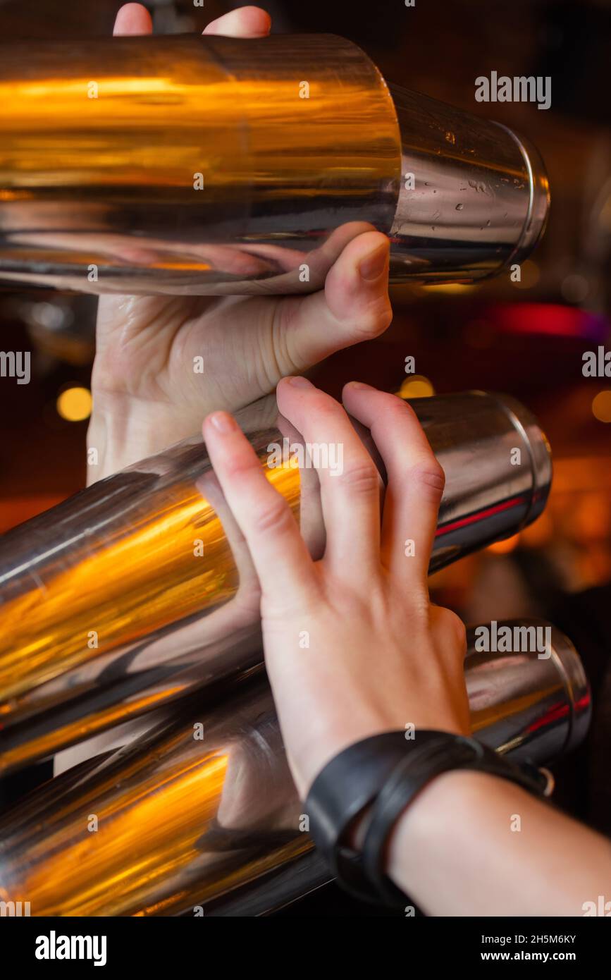 Bartender s hands holding a professional shaker against of the bar ...
